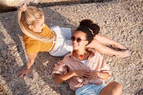 위에서 여름 휴가 유대감을 위해 해변에서 휴식을 취하고 친구들과 함께 땅에 누워 행복하고 웃습니다 미소 짓고 여행하고 여성들은 야외에서 평화 자유 휴식을 취합니다 우정에