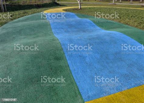 공원의 어린이 교통 놀이터 컬러 고무 타탄은 자전거에서 떨어질 때 어린이를 보호합니다 트랙의 굴곡과 기복이 있는 구절에 칼로 확인하는 기능 0명에 대한 스톡 사진 및 기타