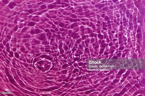 디포커스는 투명한 보라색 투명한 잔잔한 물 표면 질감을 스플래쉬 버블로 흐리게 처리했습니다 빛나는 보라색 물 잔물결 배경 수영장에서 물의 표면 보라색 거품 물이 빛납니다 0