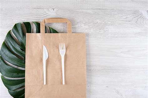 플라스틱 포크 종이 봉투에 칼 복사 공간이 있는 회색 배경에 친환경 식품 포장 및 면 에코 백 자연과 재활용 개념의 보살핌 케이터링 및 길거리 패스트푸드용 용기 가방에 대한