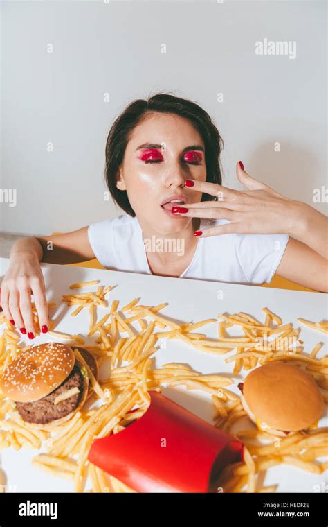 Sensual Young Woman Licking Her Finger After Eating Fast Food Over
