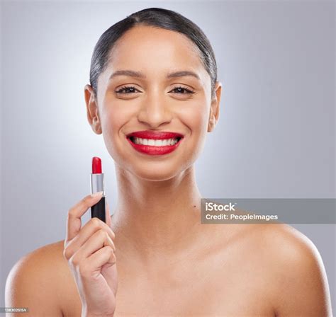 스튜디오에 홀로 서서 빨간 립스틱을 들고 포즈를 취하는 매력적인 젊은 여성의 샷 20 24세에 대한 스톡 사진 및 기타 이미지 20 24세 20 29세 건강한 생활
