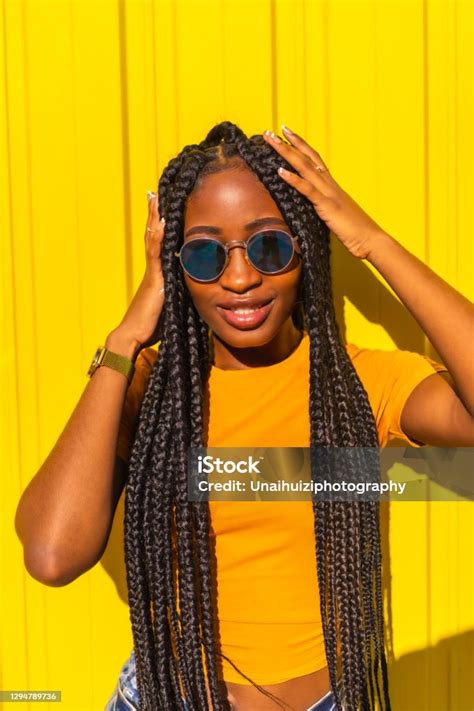 라이프 스타일 긴 머리띠 노란색 티셔츠와 노란색 배경에 짧은 청바지매력적인 검은 소녀 도시의 도시 세션에서 선글라스를 착용한 트랩 댄서 18 19세에 대한 스톡 사진 및