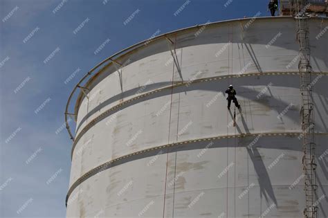 남성 작업자 다운 높이 탱크 루프 로프 액세스 저장 탱크 가스의 안전 검사 두께 용접 프리미엄 사진
