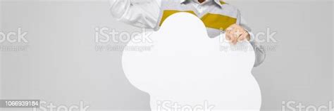 매력적인 소년 흰 셔츠 스트라이프 탱크 탑과 가벼운 청바지에 회색 배경에 서 있다 소년은 구름의 형태로 흰색 포스터를 들고 있다 남학생에 대한 스톡 사진 및 기타 이미지