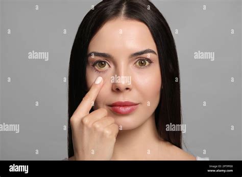 Woman Checking Her Health Condition On Grey Background Yellow Eyes As