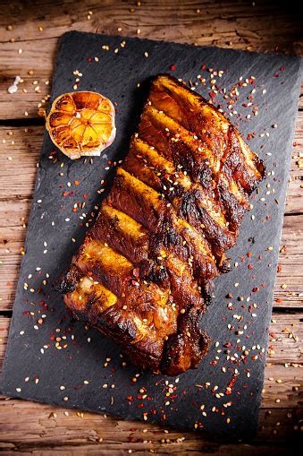 소박한 빈티지 나무 테이블 고기를 곁들인 육즙이 많은 돼지 갈비 체리 토마토 향신료 포크와 나이프 후추 로즈마리 바 질 등 어두운 배경 겨자 상단 사이드 뷰 샷 0명에 대한