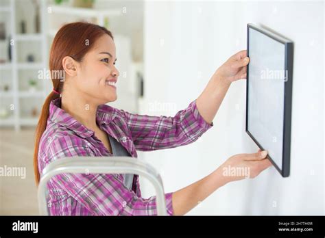 Concept Of Woman Hanging Picture Frames Stock Photo Alamy