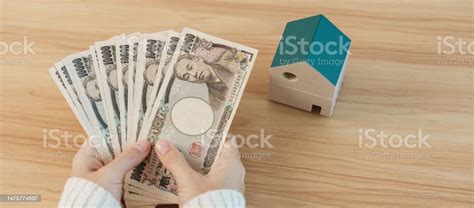 일본 엔 지폐와 하우스 모델을 들고 있는 여자 부동산 주택 모기지 일본 현금 세금 경기 침체 경제 인플레이션 투자 금융 및 저축