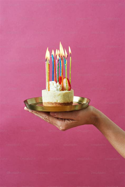 촛불이 든 케이크가 든 접시를 들고 있는 손 사진 Unsplash의 파티 이미지