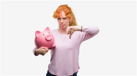 성 난 얼굴 아래로 엄지 싫어 보여주는 음수 부호 거부 개념 돼지 저금통을 들고 젊은 빨강 머리 여자 개념에 대한 스톡 사진 및 기타 이미지 Istock