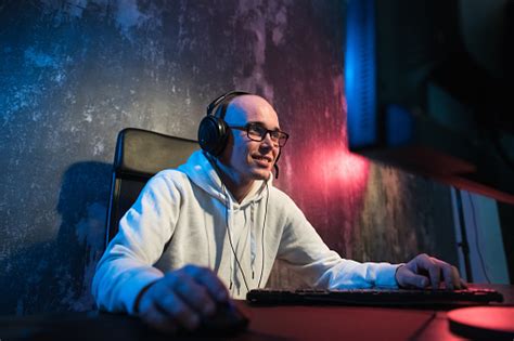 즐거운 영 컴퓨터에서 가정에서 비디오 게임을 재생 게이머의 초상화 헤드폰에 게이머 게임을 수상 하였으며 그 때문에 행복 하 고 보여주는 엄지손가락 제스처 이다 컴퓨터 게임