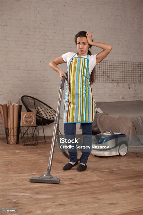 젊은 여성은 청소 업무와 집안일 세심 한 인테리어를 하 고 가정 거실 바닥에 진공 청소기를 사용 합니다 가구에 대한 스톡 사진