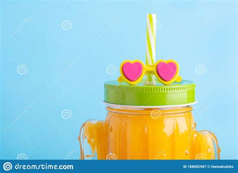 Cactus Shape Mason Jar With Orange Juice A Jar With Green Lid And Straw With Sunglasses Stock
