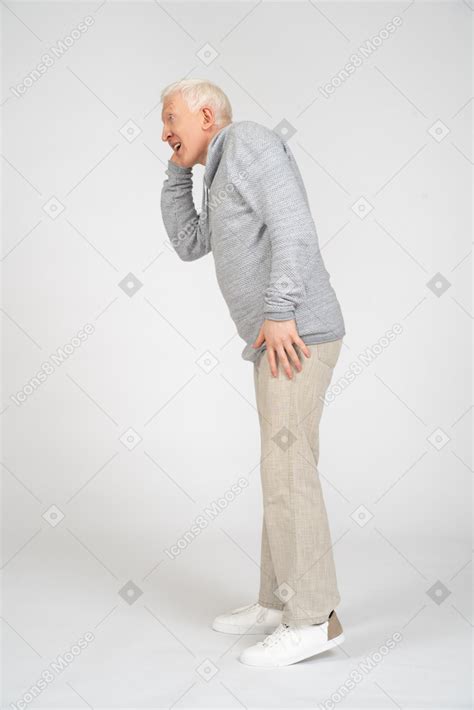 귀에 손을 대고 옆으로 팔을 들고 서 있는 남자의 옆모습 사진