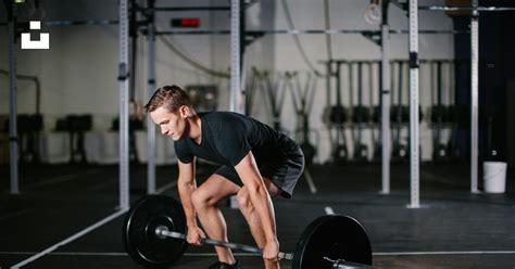 검은 티셔츠와 검은 반바지를 입은 남자가 검은 바벨을 들고 있다 사진 Unsplash의 무료 적합성 이미지