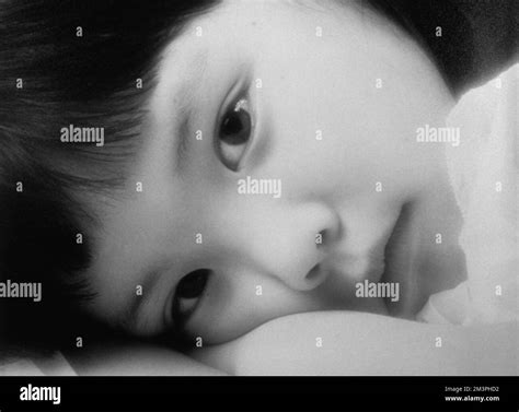 Black And White Closeup Facial Image Of An Asian Girl Laying Down Stock