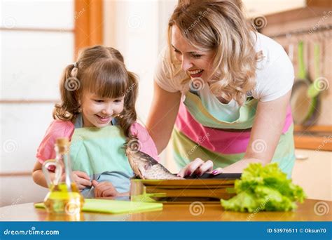 Embrome A La Muchacha Con La Mamá Que Cocina Pescados En La Cocina