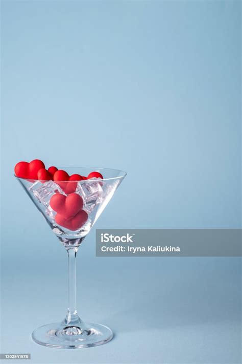 빨간 하트 모양의 설탕 사탕과 얼음 유리 파란색 배경 위에 발렌타인 데이 기념일 또는 결혼 축하 개념입니다 공간을 복사합니다