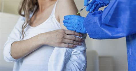 보건소에서 젊은 임산부에게 코로나19 백신 주사를 맞는 여성 의사 클리닉에서 코로나바이러스 예방 접종을 받고 있는 임산부 인구 예방 접종 개념 사진 Unsplash의