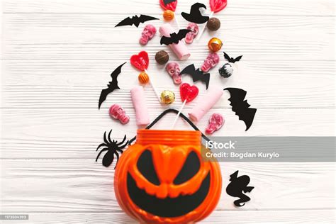 즐거운 할로윈 보내세요 할로윈 사탕은 두개골 검은 박쥐 유령 흰색 나무 배경에 거미 장식 평면 누워 잭 O 랜턴 양동이에서 유출 공간을 복사합니다 과자 안 주면 장난칠