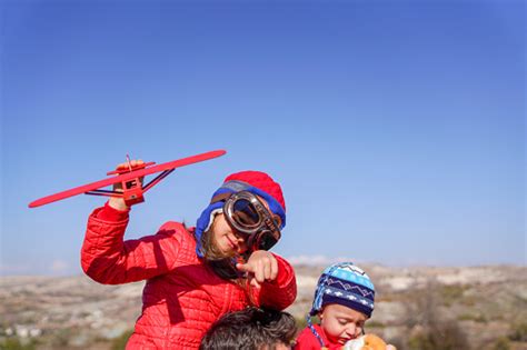 아버지와 딸은 낮에 공원에서 골판지 장난감 비행기를 가지고 놀고 있습니다 친절한 가족의 개념 야외에서 즐거운 시간을 보내는 사람들 푸른 하늘의 배경에 만든 사진입니다 날기에