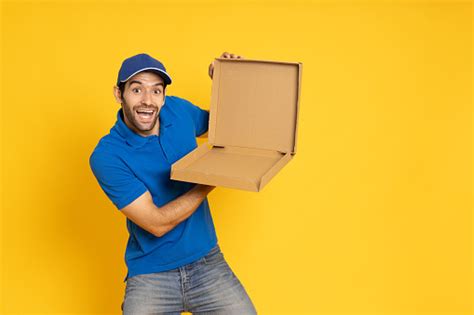 행복한 배달원은 노란색 배경에 고립된 얼굴에 미소를 띤 빈 사각형 상자를 보여줍니다 폴로에 대한 스톡 사진 및 기타 이미지 폴로 미소 사람들 Istock