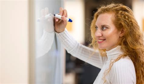 Free Photo Sideways Businesswoman Writing With A Marker