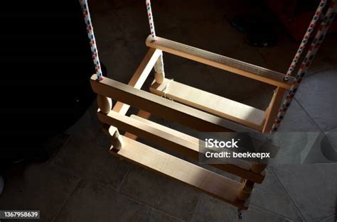 거실에는 천장 아래에서 빔에 매달린 어린이 스윙이 매달려 있습니다태양이 별장 방으로 빛납니다 가소제와 페인트없이 천연 나무로 만든 어린이 장난감및 보조 기구의 생산 및 판매