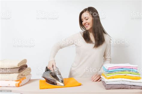 가벼운 캐주얼 다림 가족 의류 다리미와 다림 질 보드에 수건에에서 젊은 매력적인 주부 흰색 배경에 고립 된 여자입니다 가사 개념입니다 광고에 대 한 공간을 복사 합니다 가사