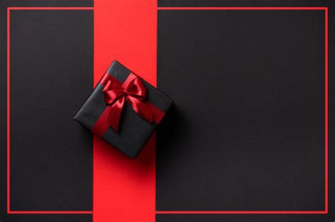 블랙 프라이데이 텍스트와 빨간 삽입을위한 장소와 어두운 배경에 활과 세련된 어두운 선물 블랙프라이데이에 대한 스톡 사진 및 기타