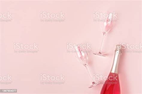크리에이티브 한 트렌디 한 플랫 누워 핑크 샴페인 병과 파스텔 배경에 분홍색 하트 모양의 색종이로 가득 한 피리 샴페인 와인에