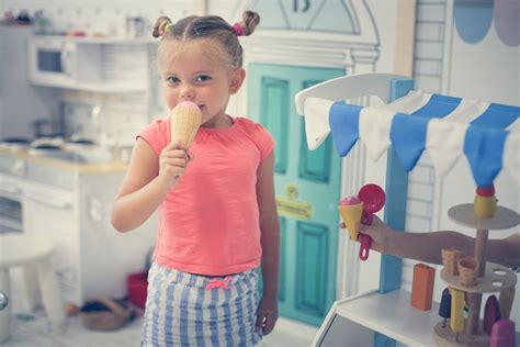 놀이터에서 어린 소녀입니다 놀이방에 서서 에이스 크림을 먹는 소녀 사진 Unsplash의 먹기 이미지