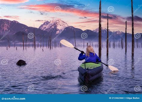 Adventurous Girl Kayaking On An Infatable Kayak In A Beautiful Lake