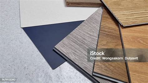 인테리어 재료 샘플 보드의 클로즈업 조합에는 재와 오크 나무 비닐 바닥 타일 파란색과 회색 패브릭 적층 회색 돌 배경에 배치된 엔지니어링 바닥 타일이 포함되어 있습니다 색상