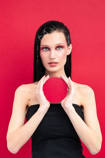 유연함 긴 곱슬 머리를 가진 어린 아름다운 소녀의 초상화는 빨간 배경에 고립 된 카메라를 바라 봅니다 여학생 젊음 아름다움 삶의 개념 광고를 위한 공간 복사 계절에 대한