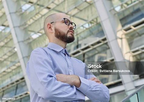 갈색 수염을 가진 한 사업가가 도시에 있는 건물의 배경을 배경으로 계단에 안경을 쓰고 서 있다 비즈니스 직원 프로그래밍 생각 거리에 대한 스톡 사진 및 기타 이미지 Istock