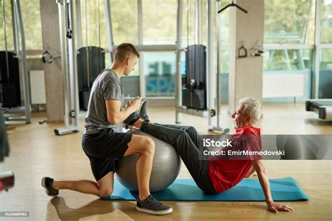 체육관에서 피트니스 공을 가지고 운동하는 시니어 남자를 돕는 개인 트레이너 2명에 대한 스톡 사진 및 기타 이미지 2명 강사 건강한 생활방식 Istock