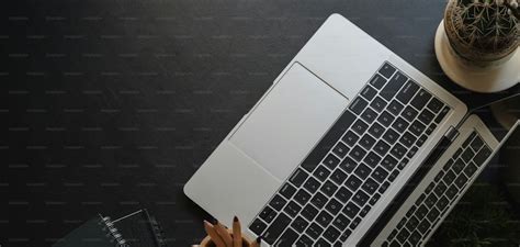 검은 테이블 배경에 노트북 컴퓨터와 사무용품이 있는 어두운 현대 작업장의 상위 뷰 사진 Unsplash의 랩톱 이미지