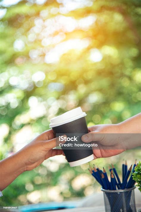 사무실 책상에서 함께 커피를 마시는 여성 사업가 동료와 손을 잡는다 우정 팀워크는 카페인 뜨거운 찻잔 신선도 라이프 스타일을 유지합니다 사업가들은 팀에게 커피 잔을 준다 2