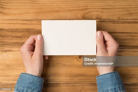 빈 공간이있는 고립 된 나무 테이블 배경에 흰색 종이 카드를 들고있는 손의 1 인칭 탑 뷰 사진 개념에 대한 스톡 사진 및 기타 이미지 Istock