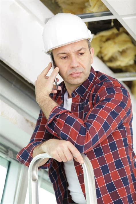 Handsome Repairman Using Mobile Phone While Standing In Ladder Stock Photo Image Of