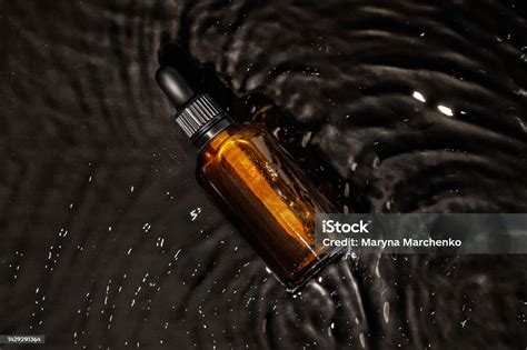 물에 피펫이있는 화장품 병 호박색 유리 파도 검은 배경 어두운 파도 화장품 병 기름 토너 강장제 혈청 산 검은색에 대한 스톡 사진 및 기타 이미지 Istock