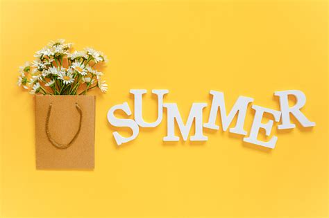 노란색 배경에 공예 패키지에 흰색 볼륨 문자와 필드 Chamomiles 꽃에서 텍스트 여름 인사말 카드 플랫 레이 카피 공간 개념 안녕하세요 여름 여름 0명에 대한 스톡