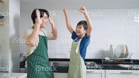 앞치마를 두른 아시아인 아버지와 어린 아들이 부엌에서 설거지를 한 후 행복해 보인다 가족 생활 개념 2명에 대한 스톡 사진 및 기타 이미지 Istock