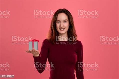 흥분 예쁜 갈색 머리 소녀는 어두운 분홍색 배경에 고립 된 리본으로 현재 상자를 들고 카메라에 미소 특별 행사를 축하합니다 갈색 머리에 대한 스톡 사진 및 기타 이미지