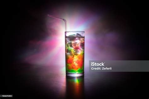 어두운 톤의 연기가 자욱한 배경이나 유리에 화려한 칵테일에 튀는 칵테일 유리 파티 클럽 엔터테인먼트 혼합 된 빛 0명에 대한 스톡 사진 및 기타 이미지 Istock