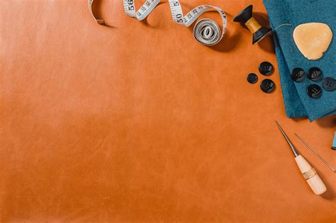 재봉 도구가있는 주황색 질감의 배경 배경에 천연 가죽에 공간을 복사합니다 바느질 도구 및 액세서리프레임 맨 위 보기 0명에 대한