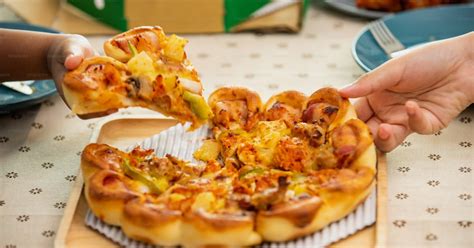 행복한 아프리카 가족 부모와 두 어린 딸이 함께 프라이드 치킨과 피자를 먹고 있습니다 아버지와 어머니와 귀여운 아이 소녀 아이가 집에서 함께 먹고 즐겁게 식사를 나누고