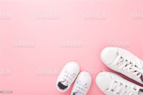 밝은 분홍색 테이블 배경에 어머니와 딸 흰색 스포츠 신발입니다 파스텔 색상입니다 텍스트 따옴표 또는 속담을위한 빈 장소 근접